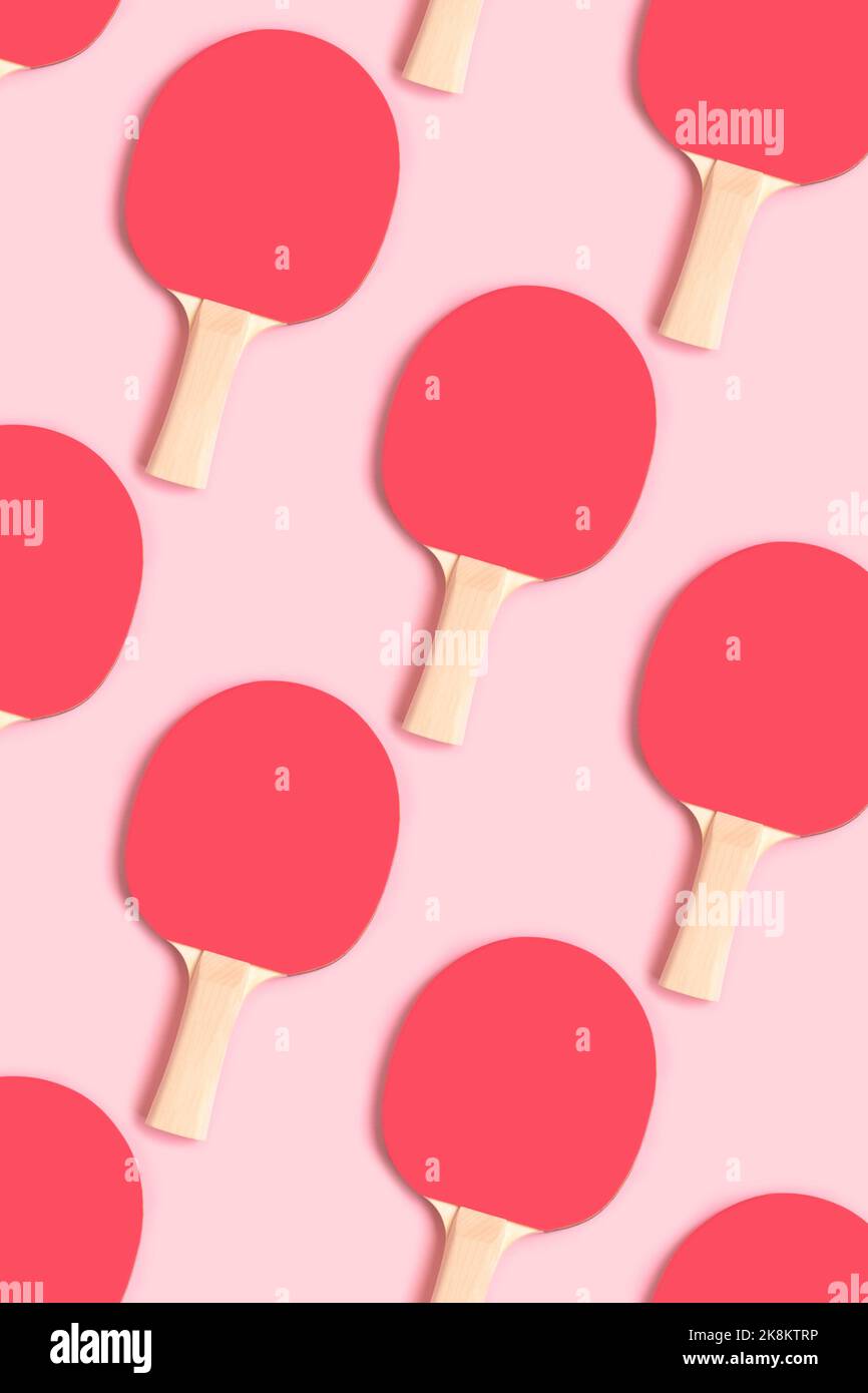 Repetitive pattern made of red tennis racket on a pink pastel ...