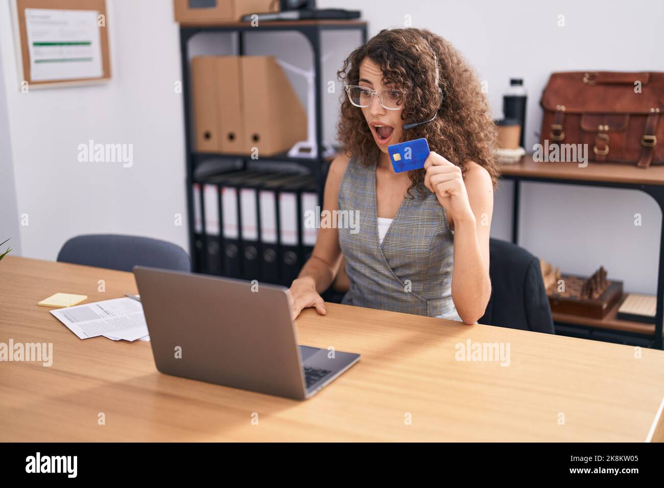 Hispanic woman with curly hair wearing call center agent headset ...