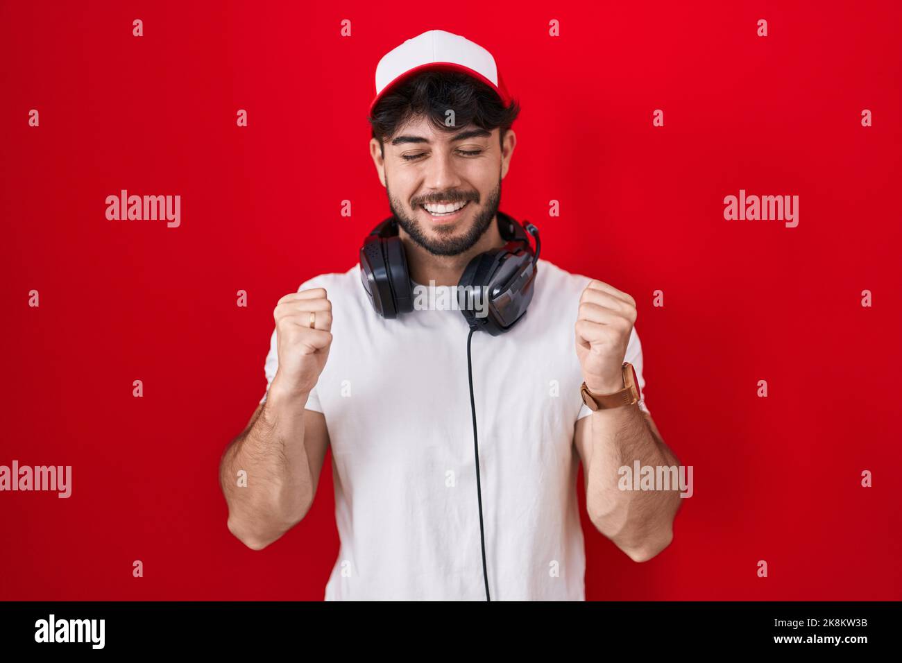 Hispanic man with beard wearing gamer hat and headphones excited for ...