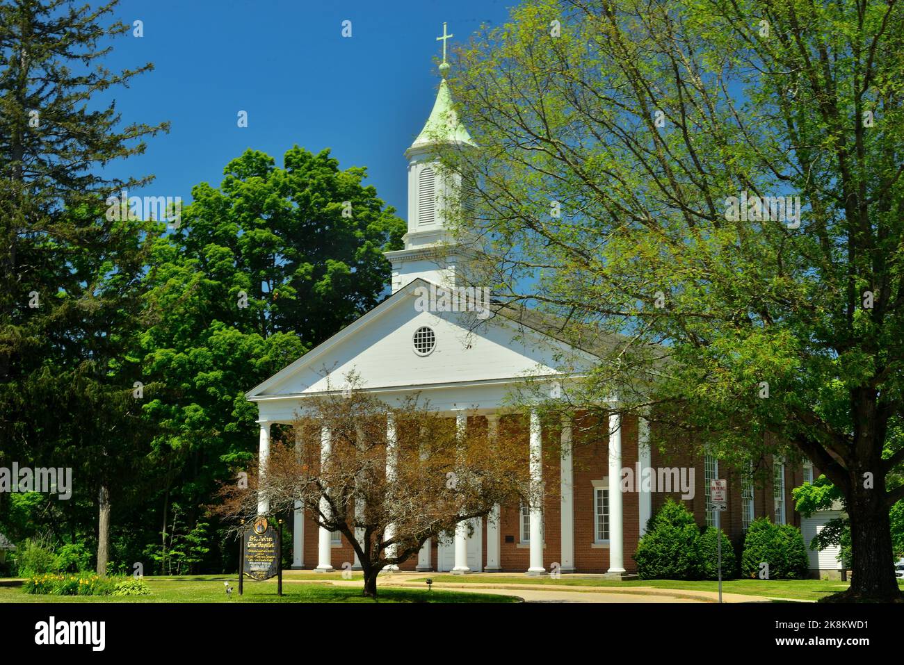 A white church building with tall trees Stock Photo - Alamy