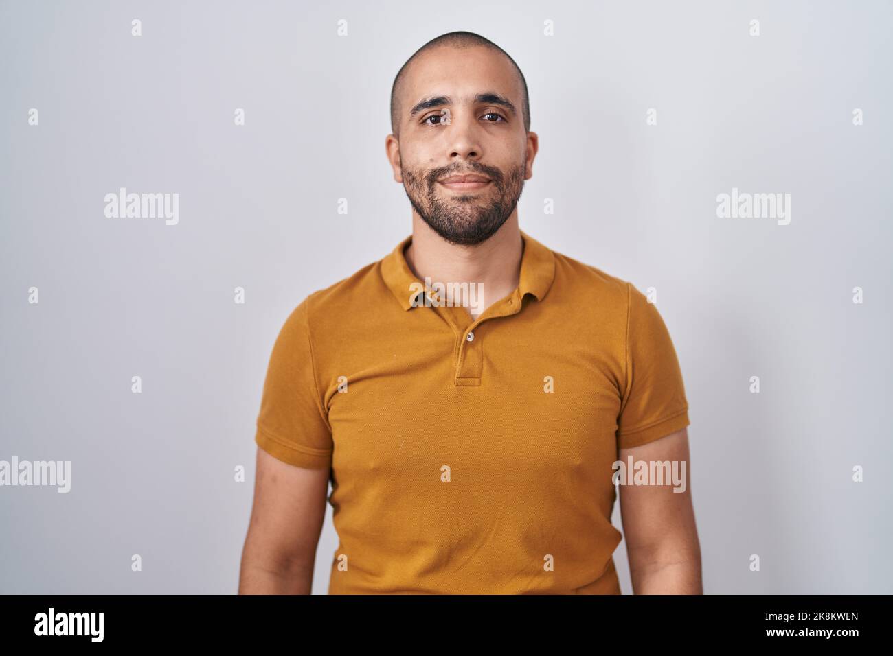 Hispanic man with beard standing over white background relaxed with ...