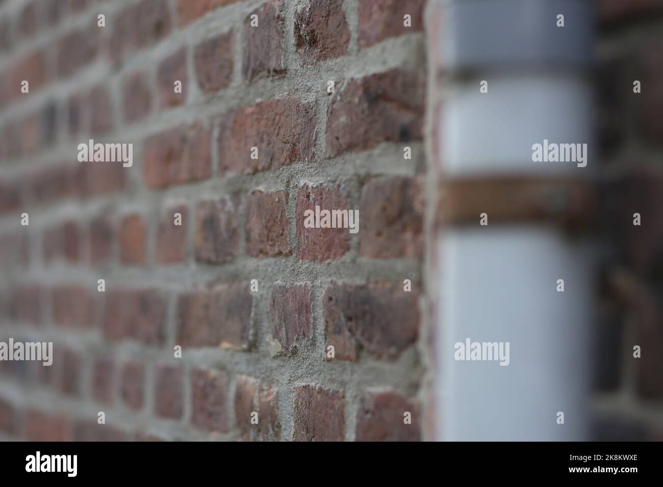 A shallow focus of a brick wall with a water pipe Stock Photo - Alamy