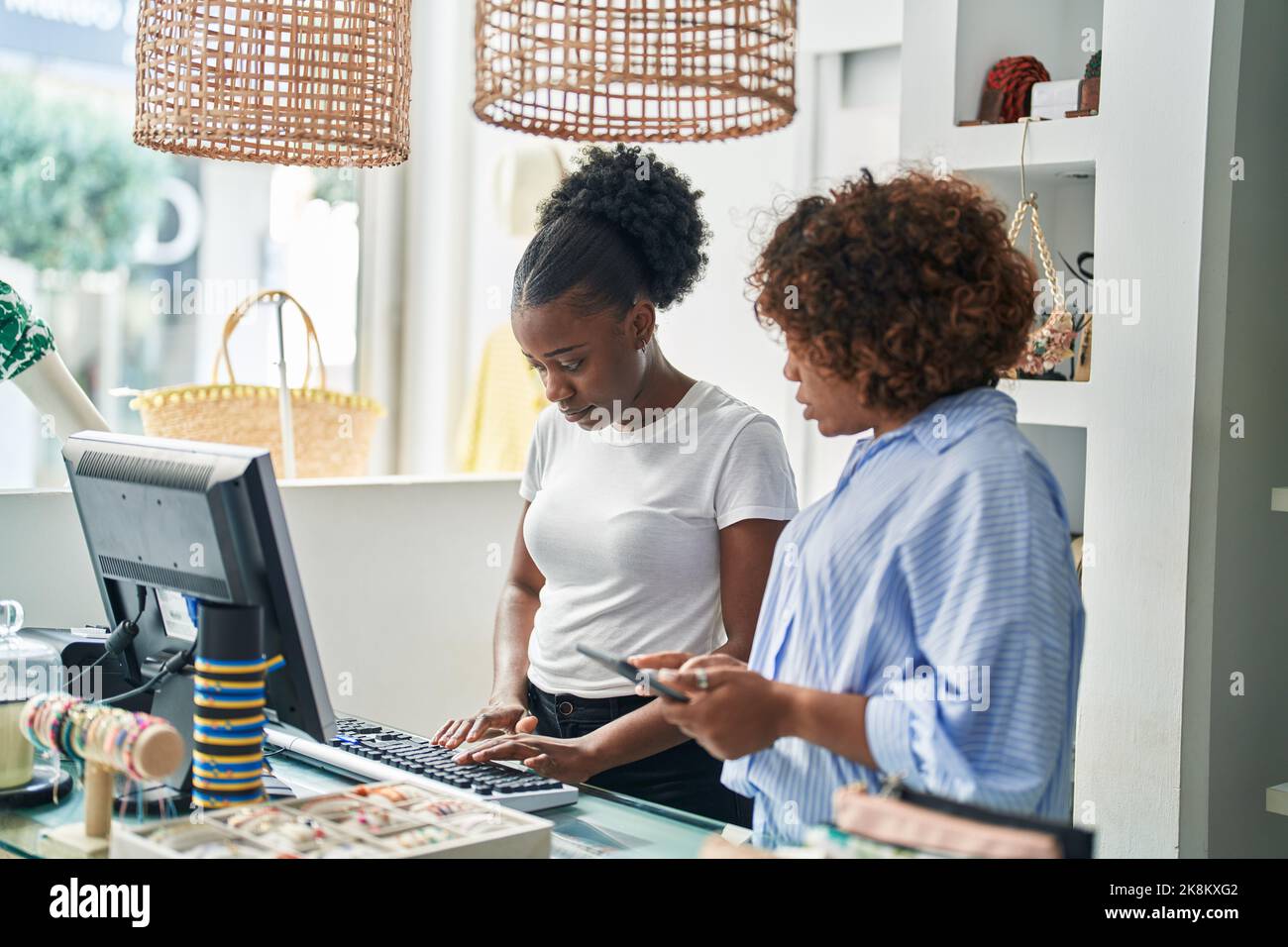African american women shop assistants using touchpad and computer at ...