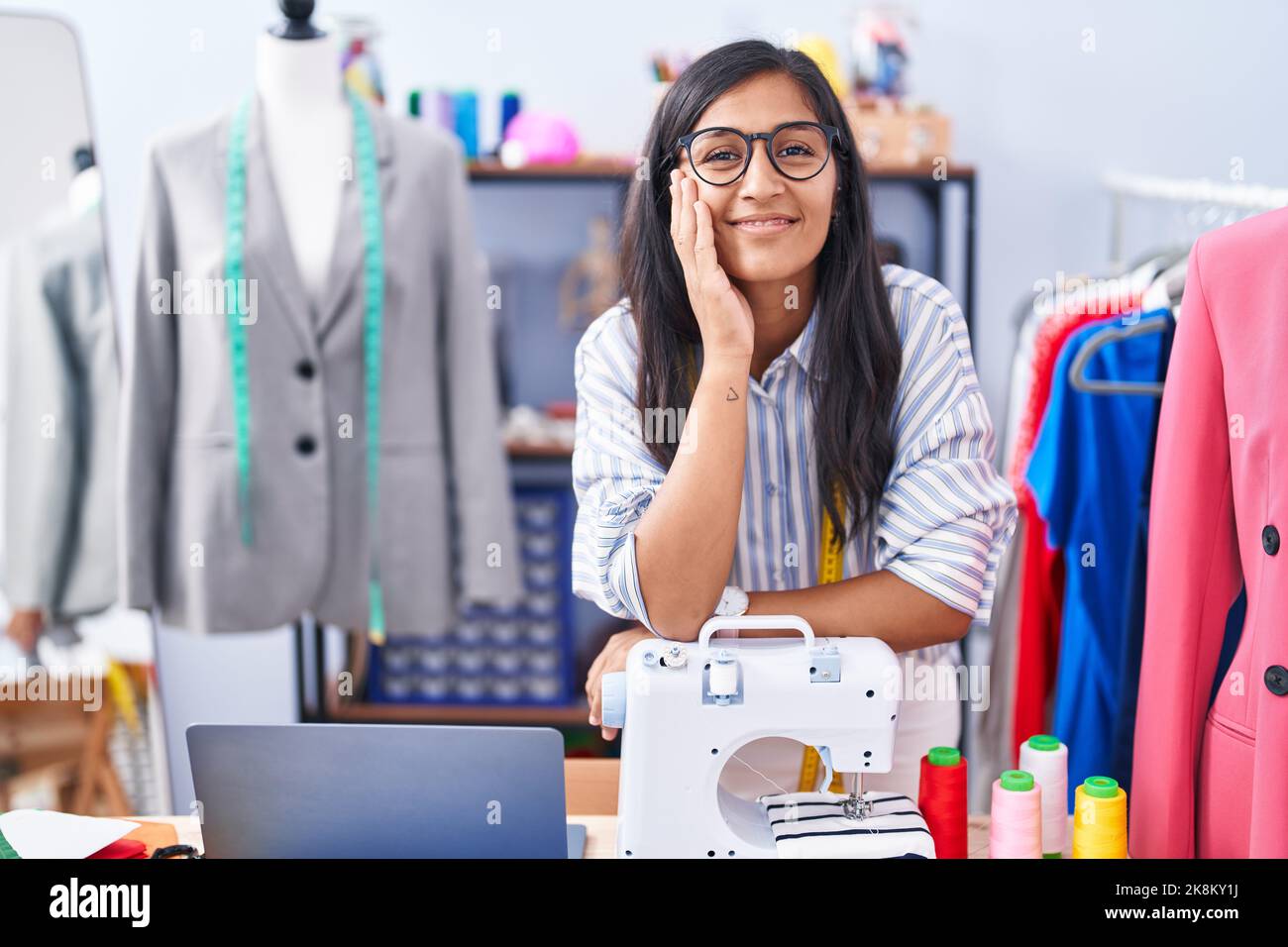 Young beautiful hispanic woman tailor smiling confident leaning on ...