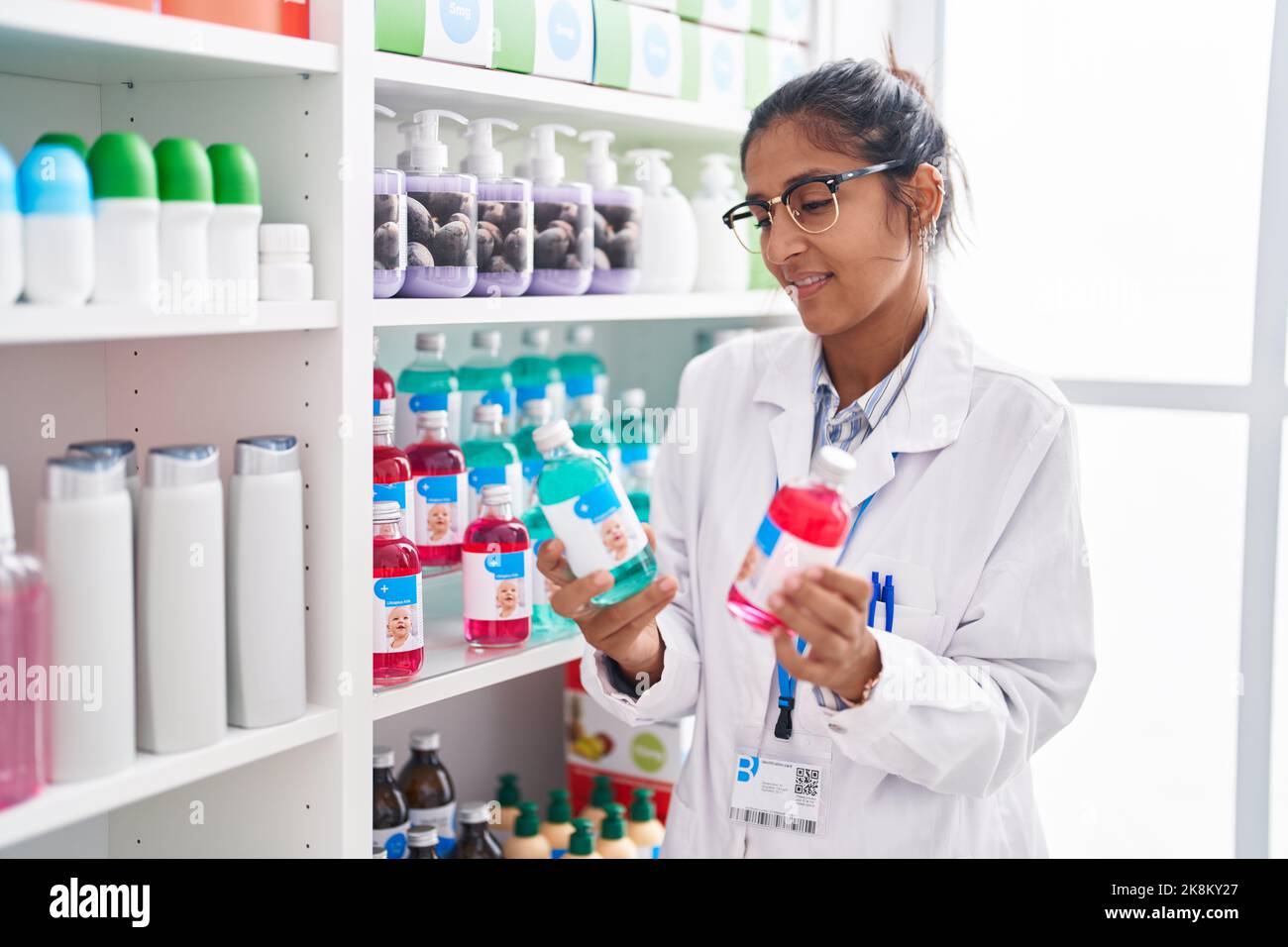 Young beautiful hispanic woman pharmacist smiling confident holding ...