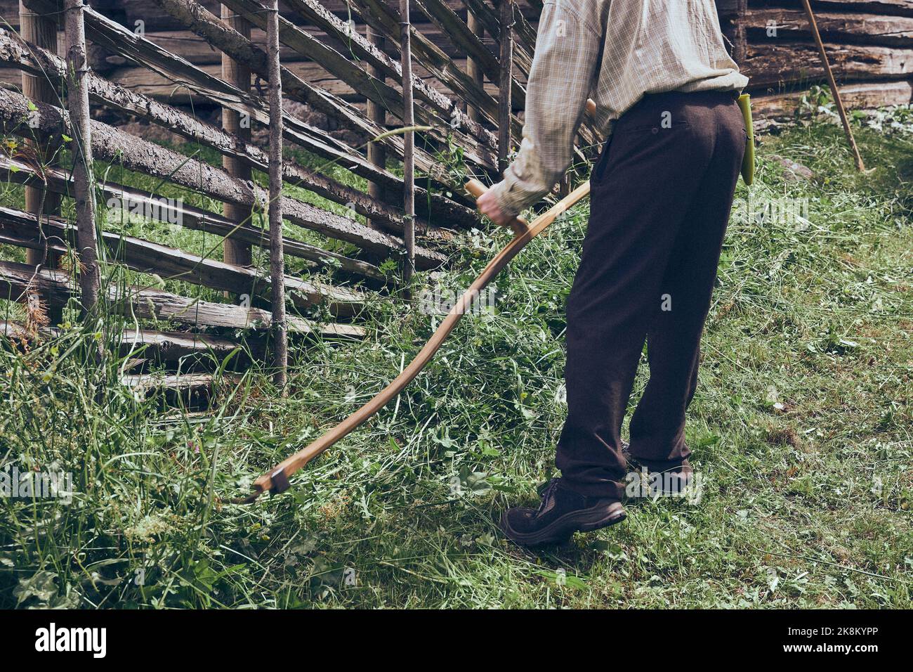 A beautiful shot of a man cutting grass with scythe Stock Photo - Alamy
