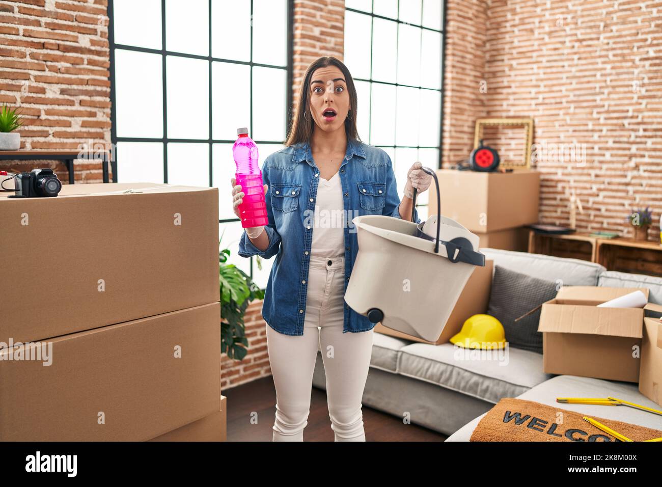 Hispanic woman moving to a new home cleaning the floor afraid and ...