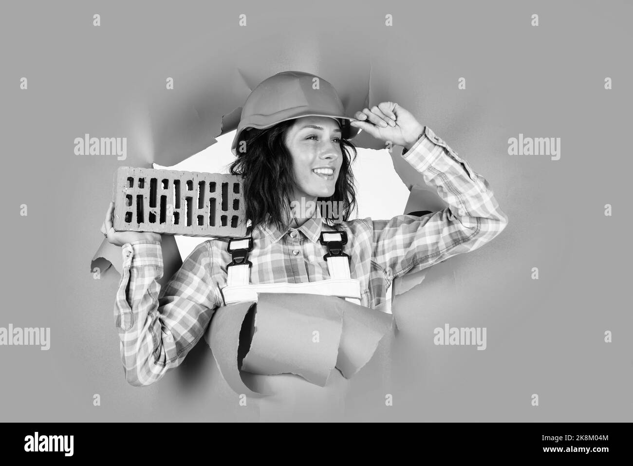 cheerful woman wear safety helmet. girl carpenter use brick. happy ...