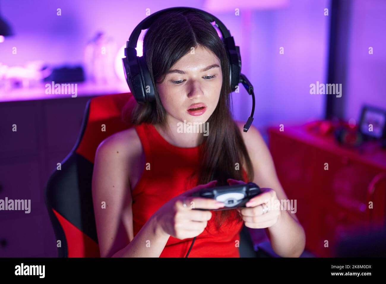 Young caucasian woman streamer playing video game using joystick at ...