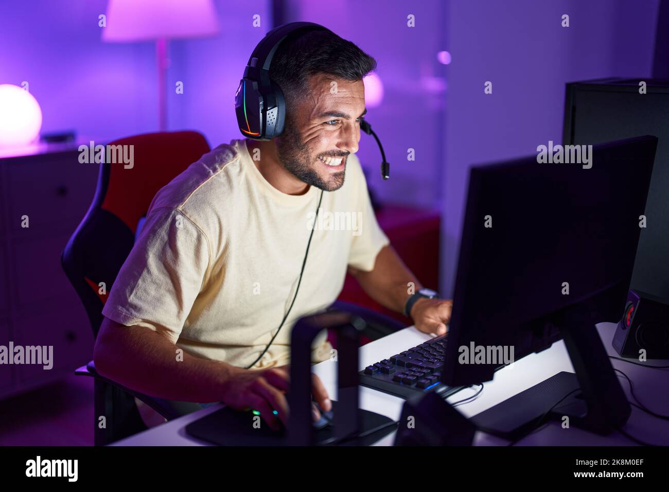 Young hispanic man streamer playing video game using computer at gaming ...