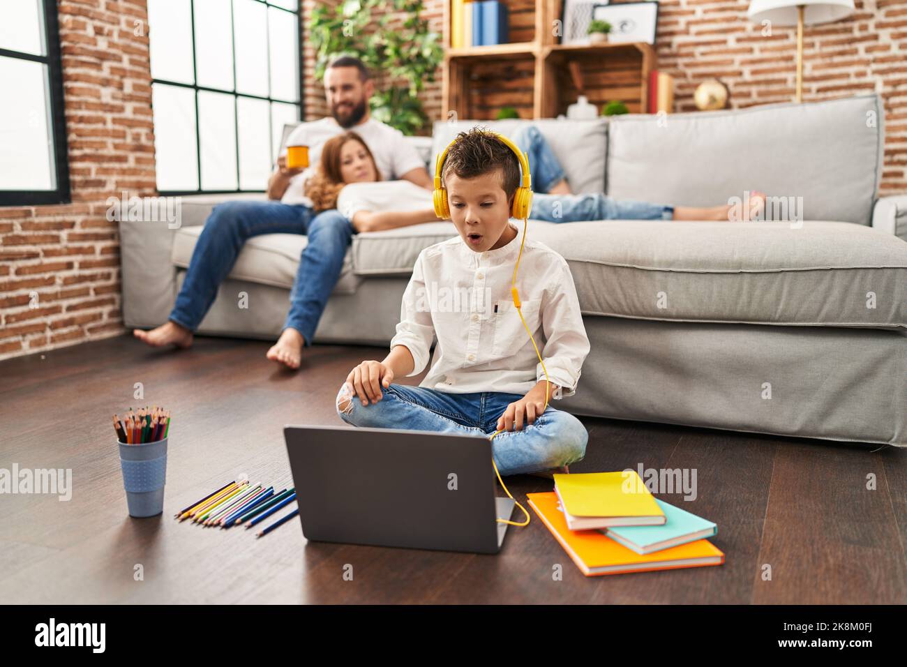 Family of three doing homework at home scared and amazed with open ...