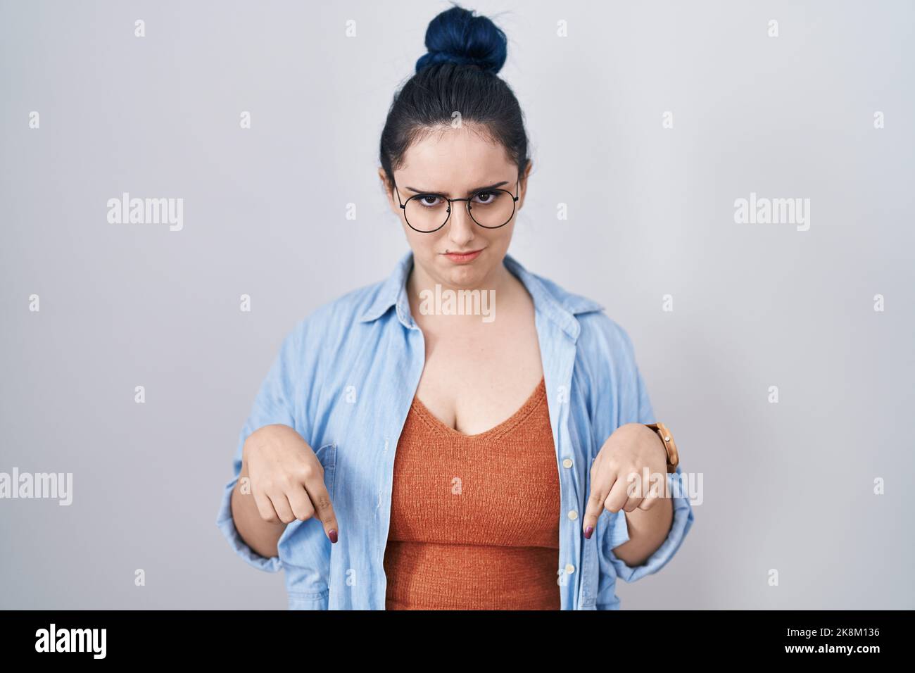 Young modern girl with blue hair standing over white background ...