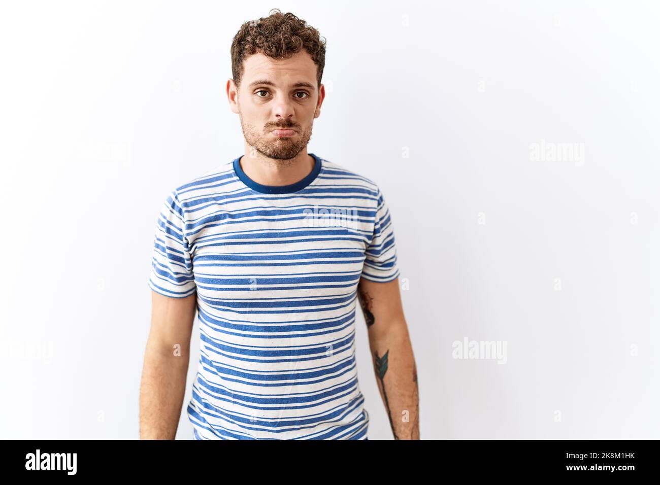 Handsome young man standing over isolated background depressed and ...
