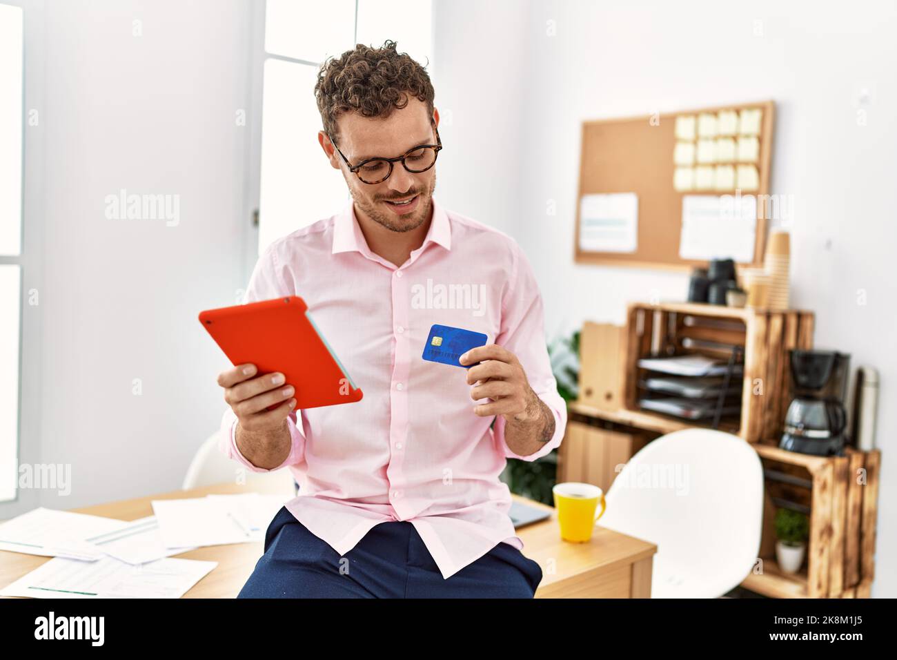 Young hispanic man smiling confident using touchpad and credit card at ...