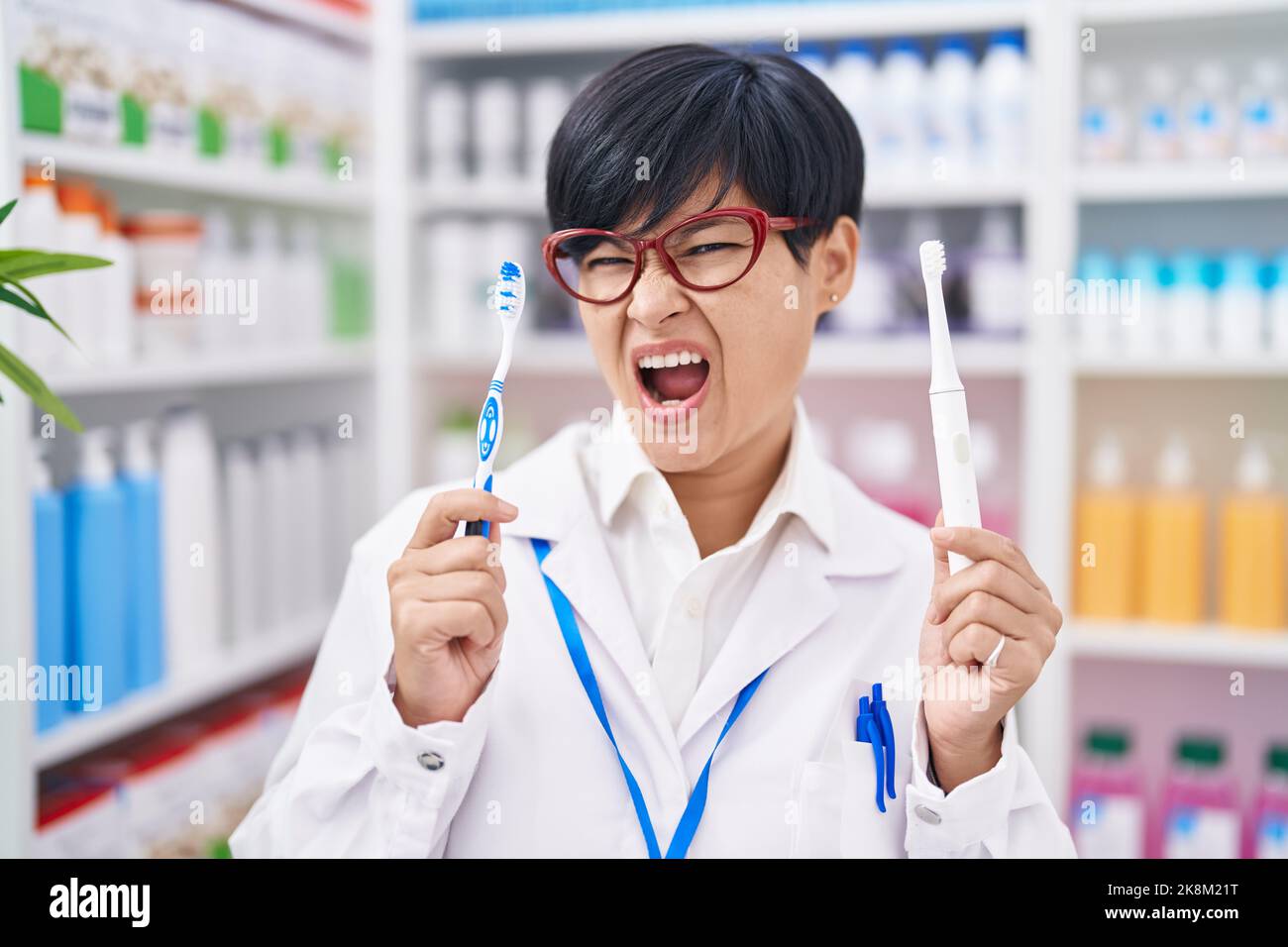 Young asian woman with short hair doing toothbrush comparative at ...