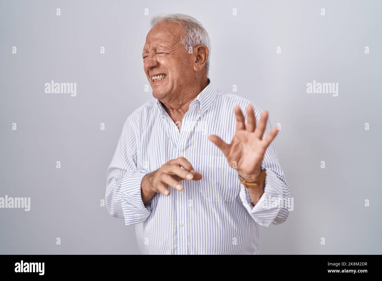 Senior man with grey hair standing over isolated background disgusted ...