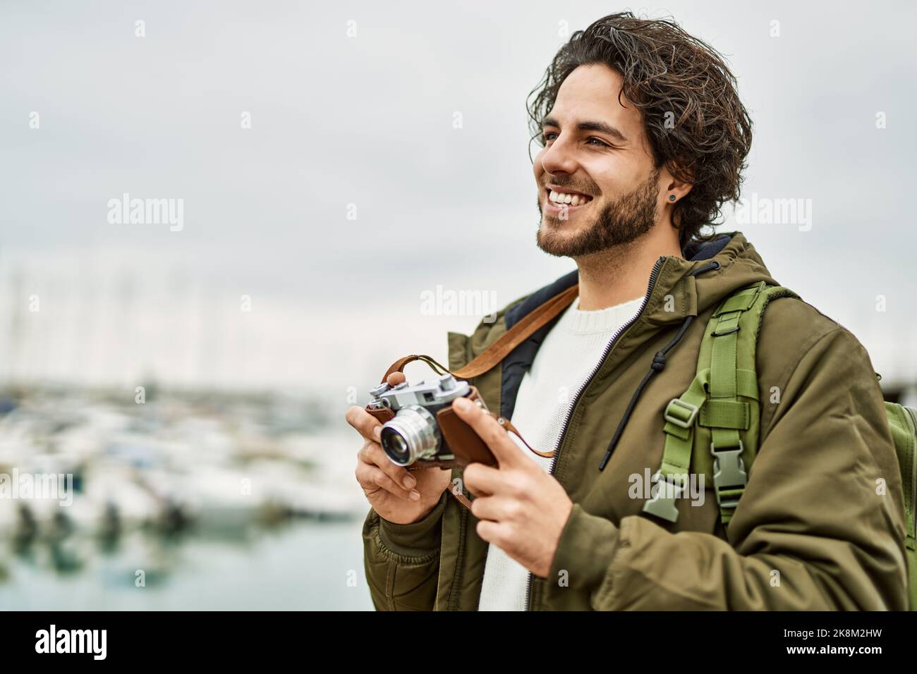Handsome hispanic man using vintage camera by marina port Stock Photo ...