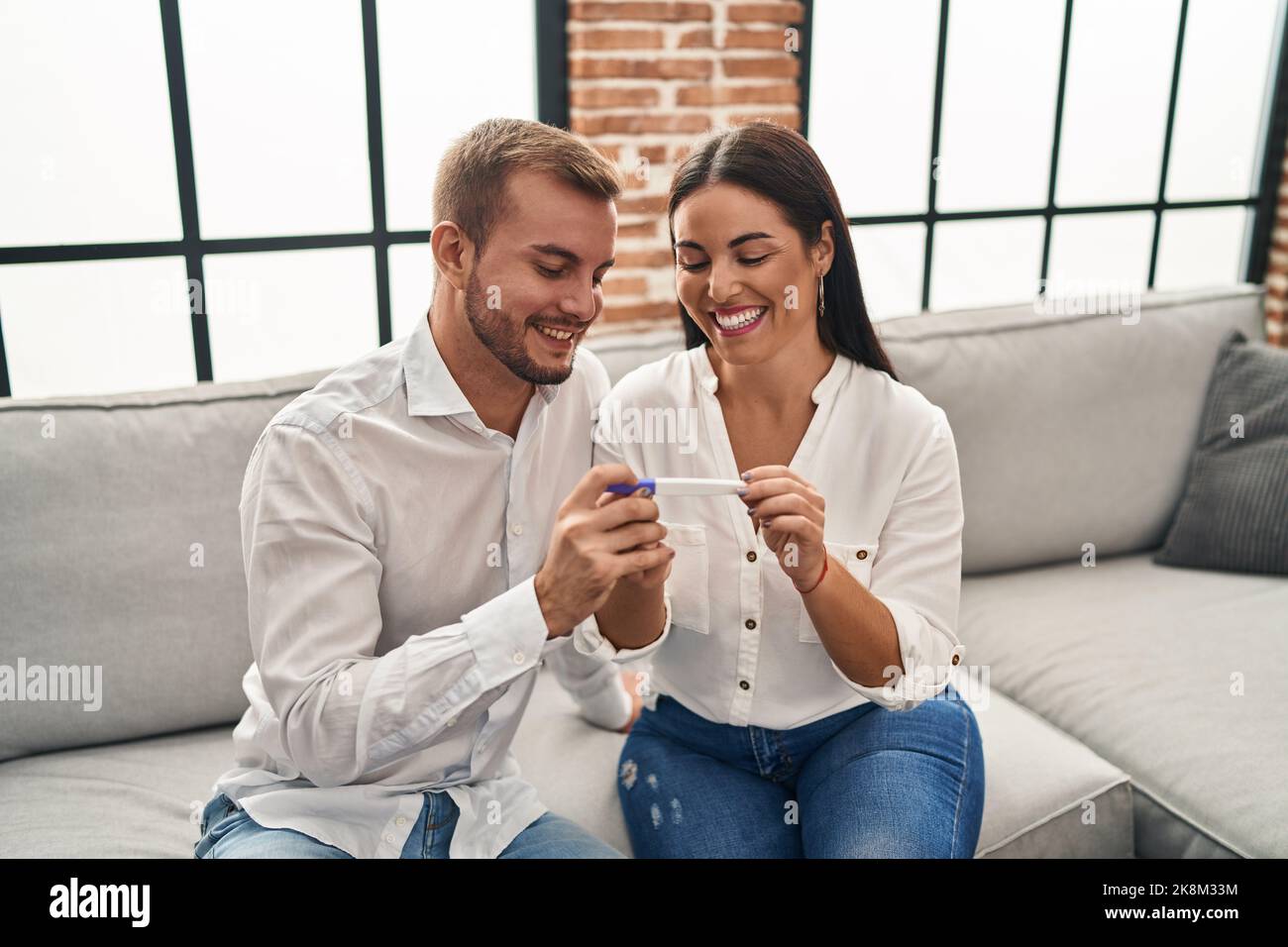 Man and woman couple smiling happy holding pregnancy test at home Stock ...