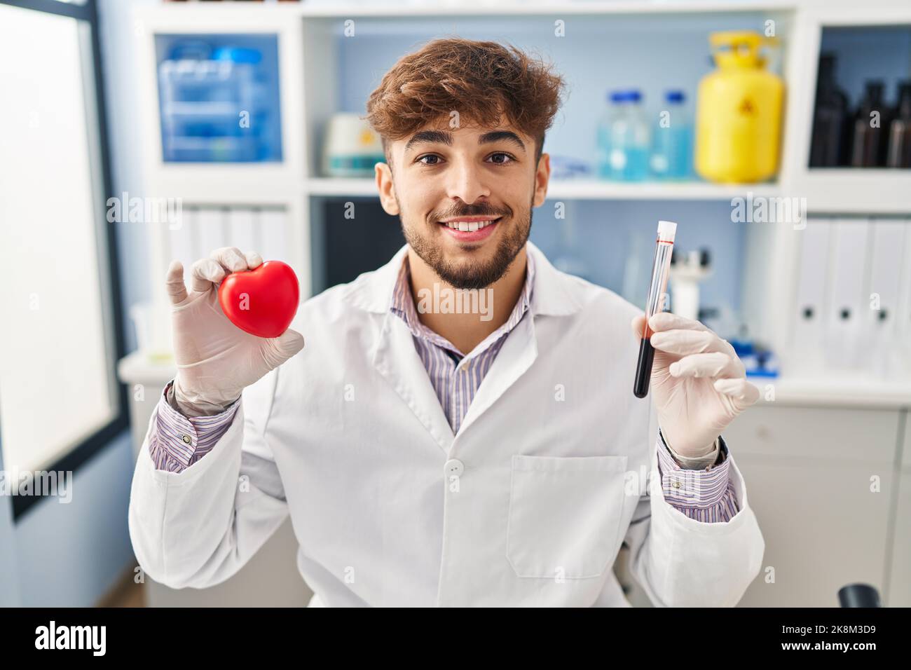 Arab man with beard working at scientist laboratory holding blood ...