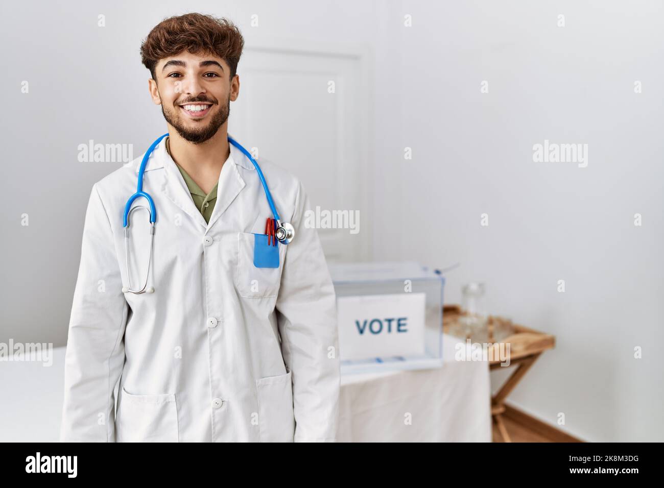 Young arab doctor man at political election by ballot looking positive ...