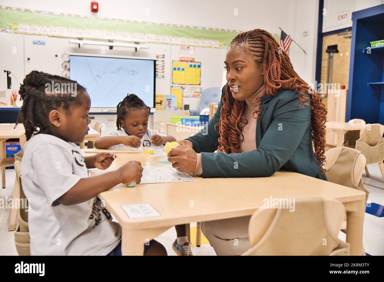 An African American Black teacher teaching young black students in the ...
