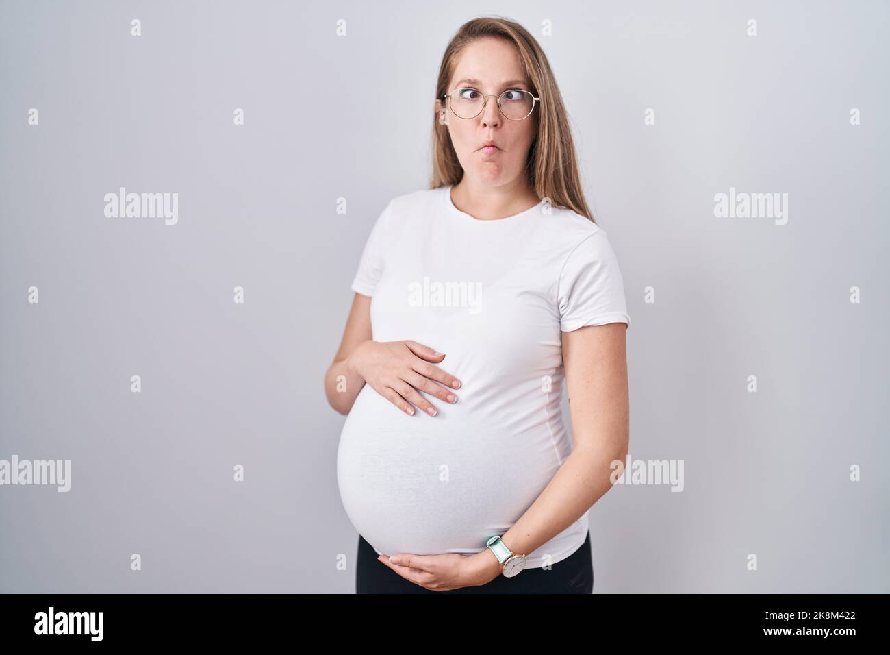 Young pregnant woman expecting a baby, touching pregnant belly making ...