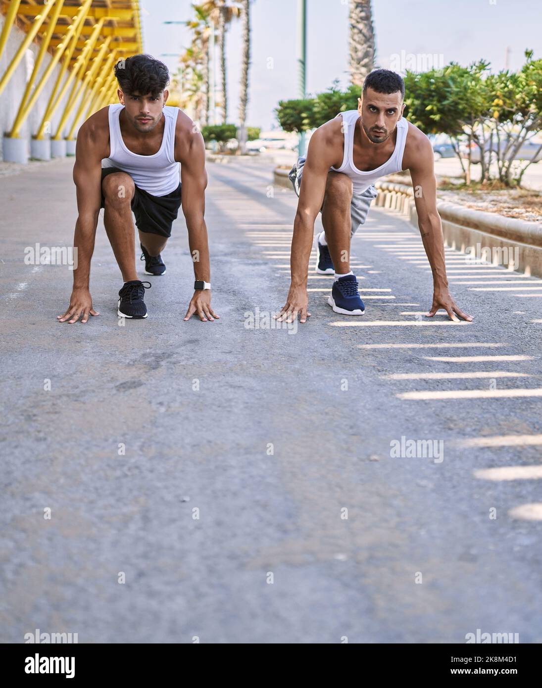 Two hispanic men sporty couple on start race position at street Stock ...