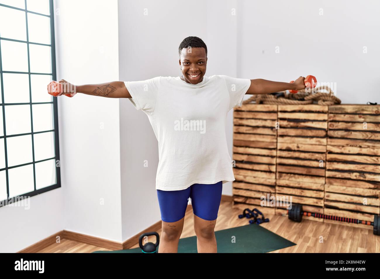 Young african man training with dumbbells at the gym Stock Photo - Alamy