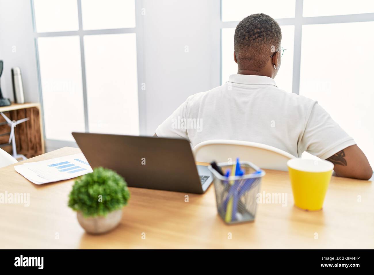 Young african man working at the office using computer laptop standing ...