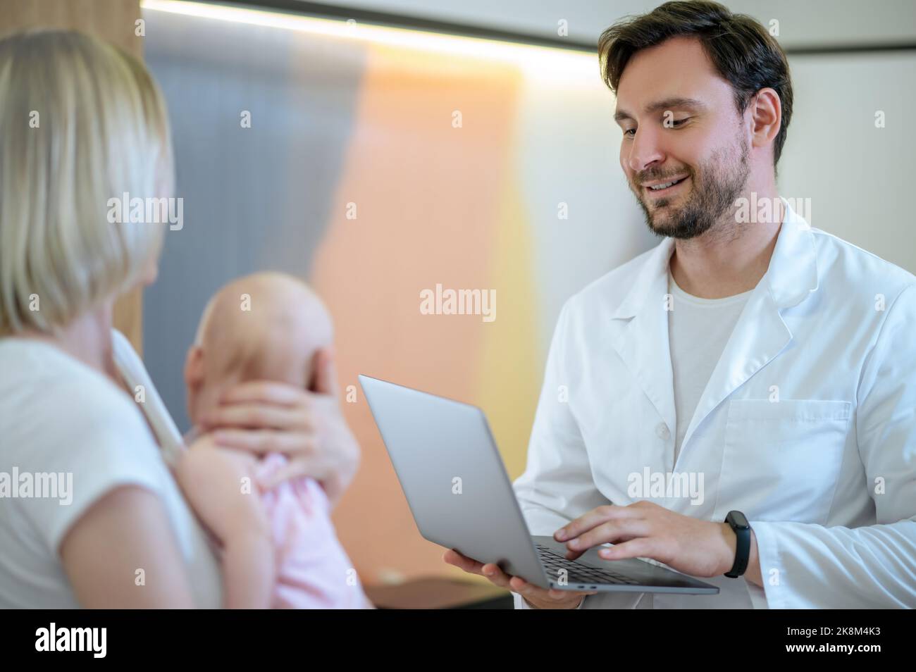 Focused pediatric doctor using the computer during the consultation ...