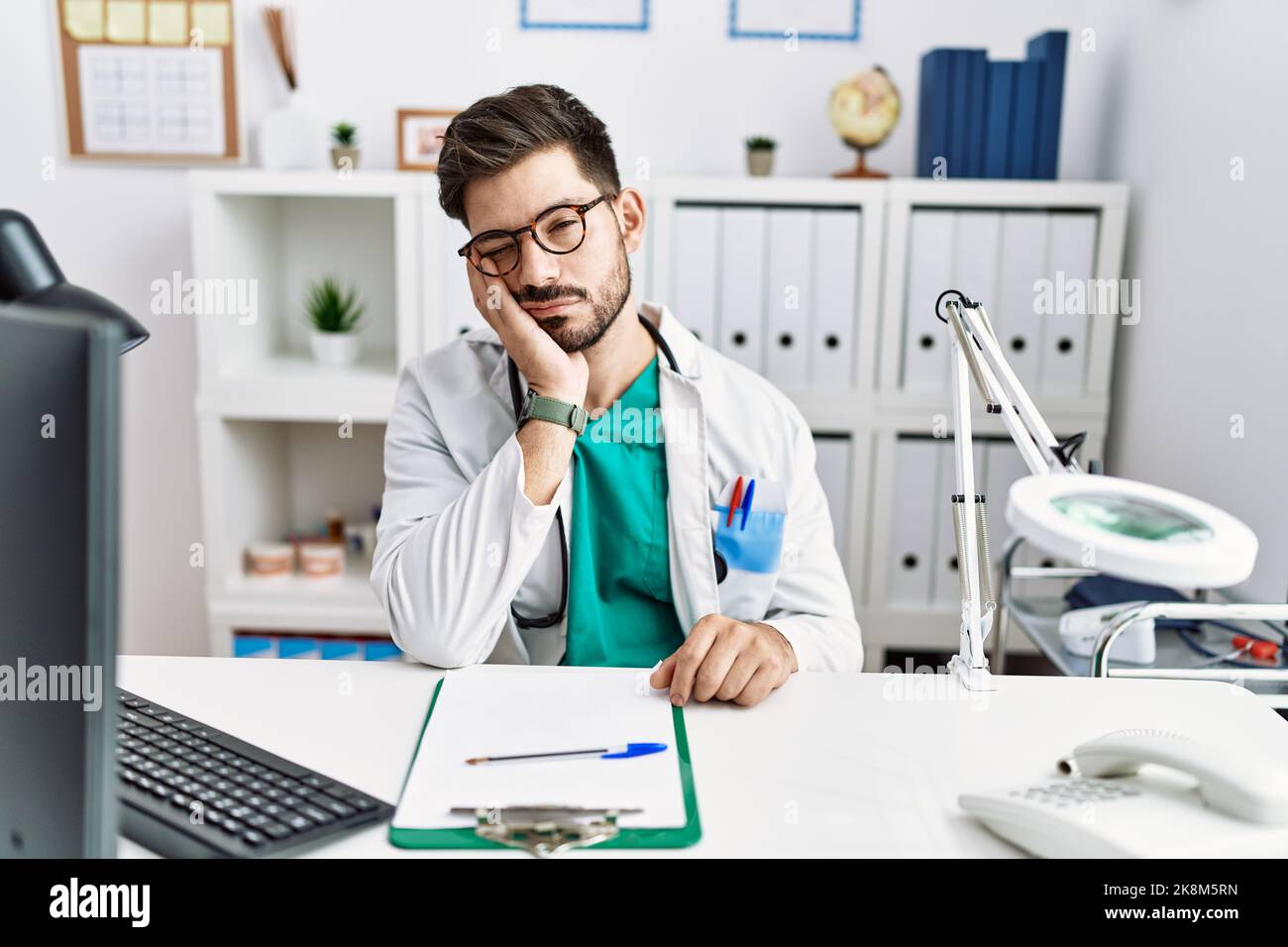 Young man with beard wearing doctor uniform and stethoscope at the ...