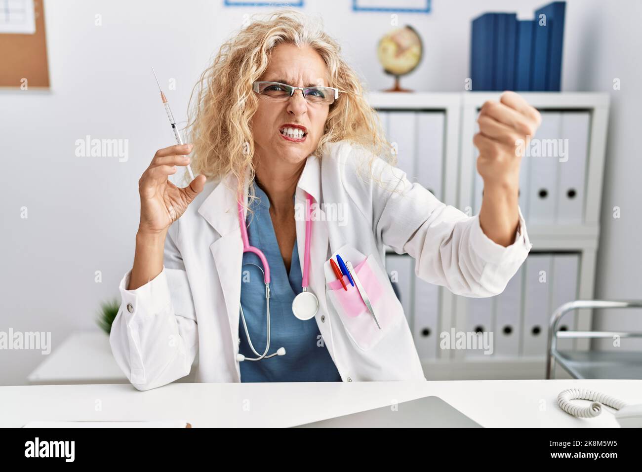 Evil woman holding syringe hi-res stock photography and images - Alamy