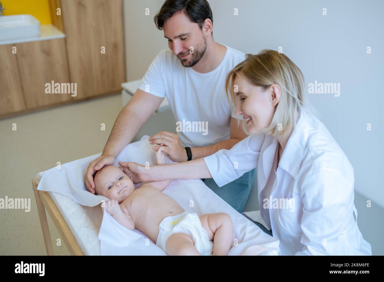 Experienced doctor performing a neonatal exam in the dad presence Stock ...