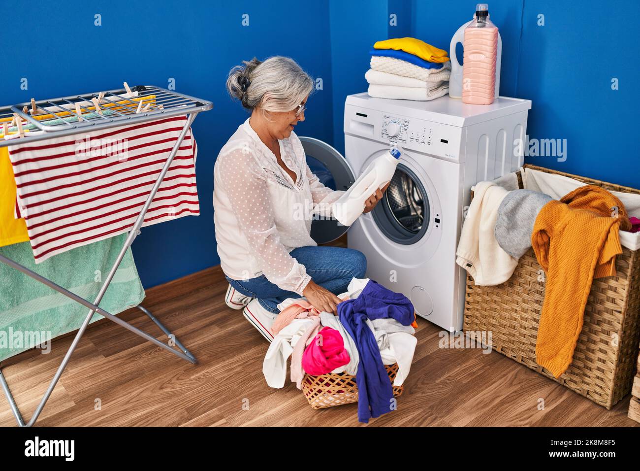 Middle age woman washing clothes at laundry room Stock Photo - Alamy