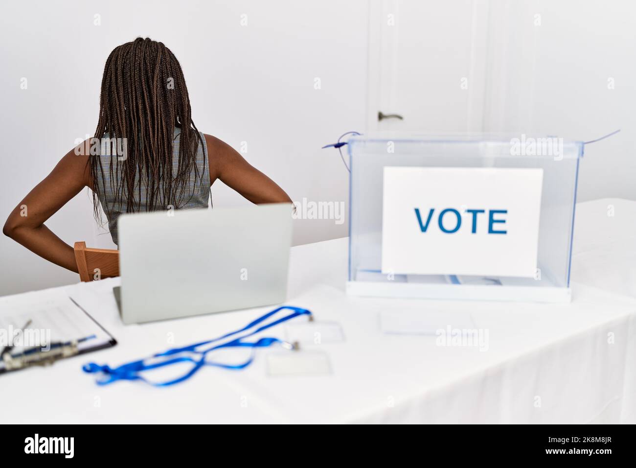 Young african american woman working at political election sitting by ...