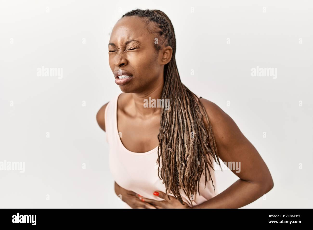 Black woman with braids standing over isolated background with hand on ...