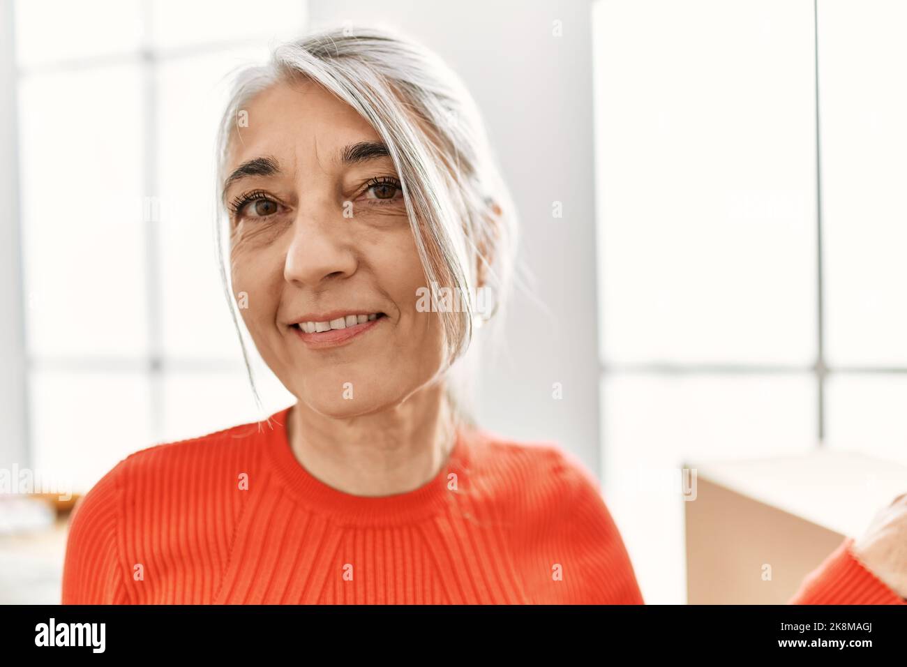 Middle age grey-haired woman smiling confident standing at new home ...