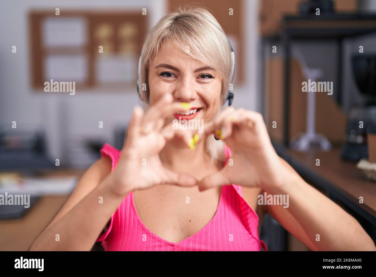 Young caucasian woman wearing call center agent headset smiling in love ...