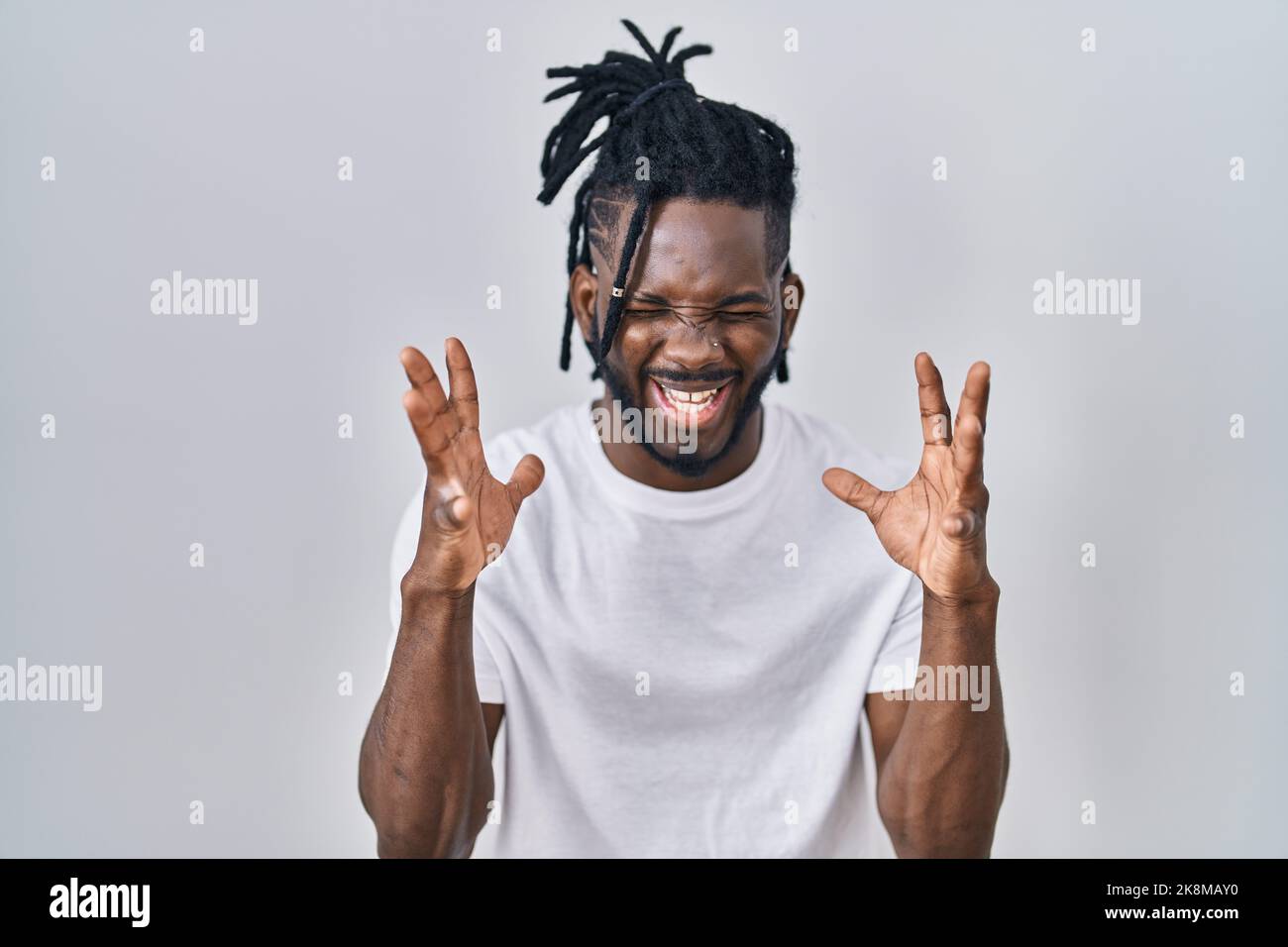 African man with dreadlocks wearing casual t shirt over white ...