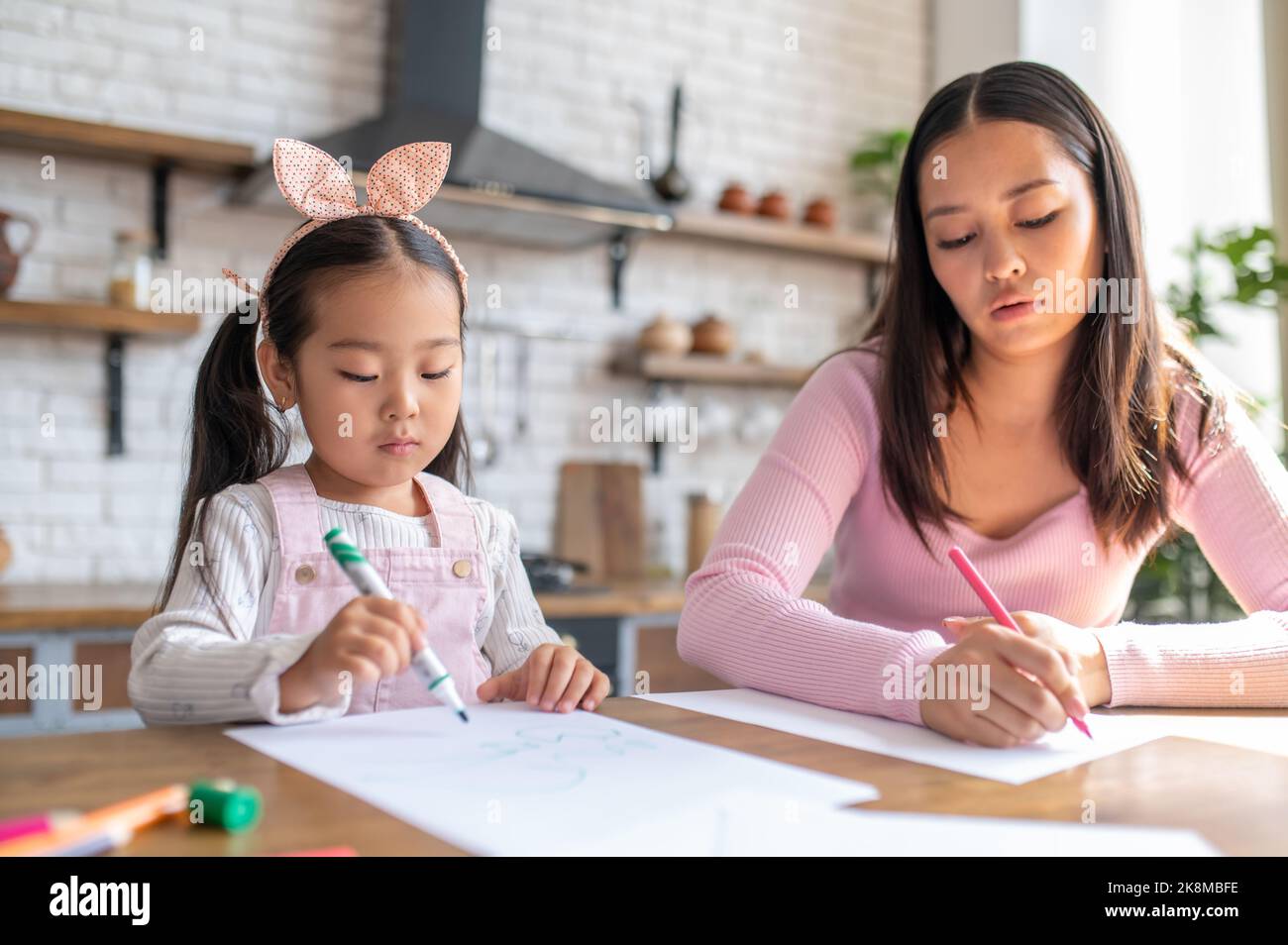 Child and her mother involved in creative hobby Stock Photo - Alamy