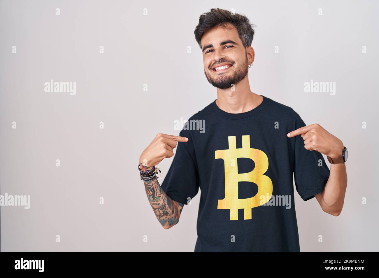 Young hispanic man with tattoos wearing bitcoin t shirt looking ...