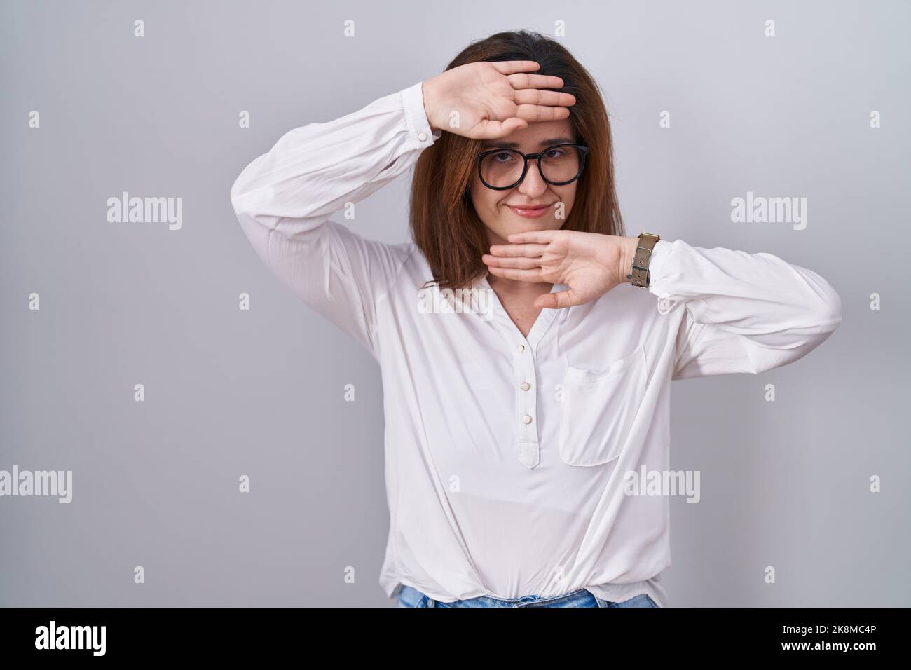 Brunette woman standing over white isolated background smiling cheerful ...