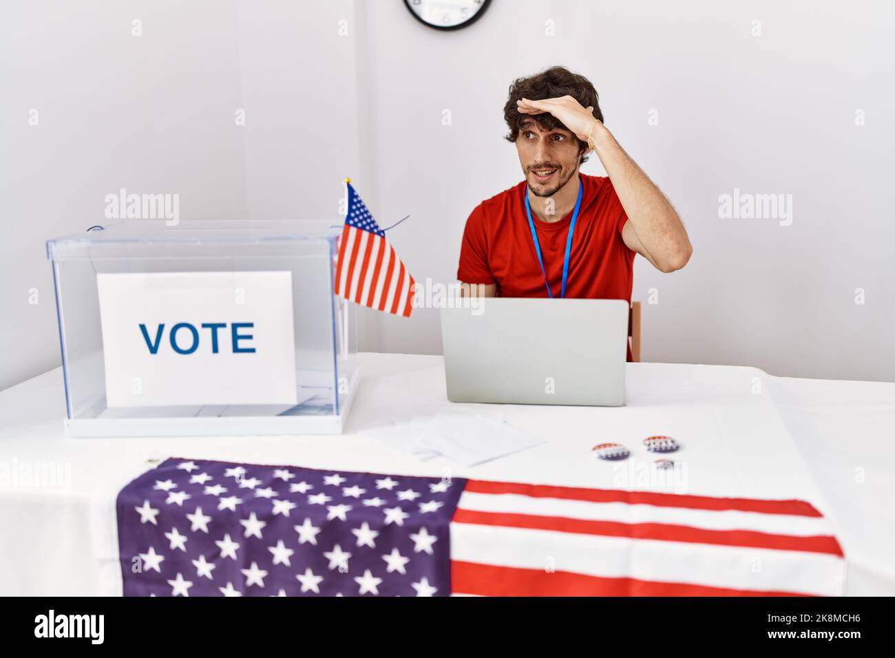 Young hispanic man at political election sitting by ballot very happy ...