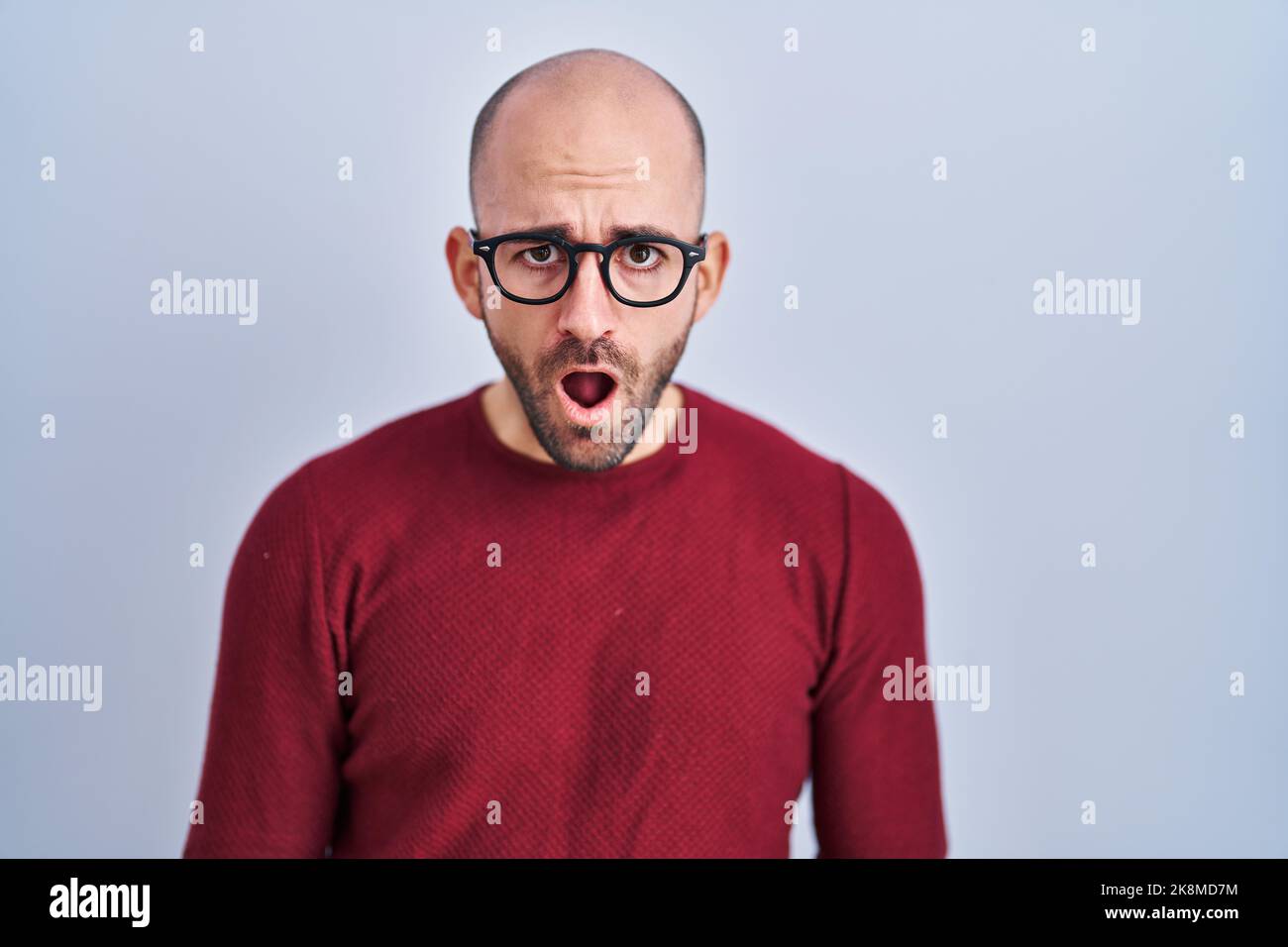 Young bald man with beard standing over white background wearing ...
