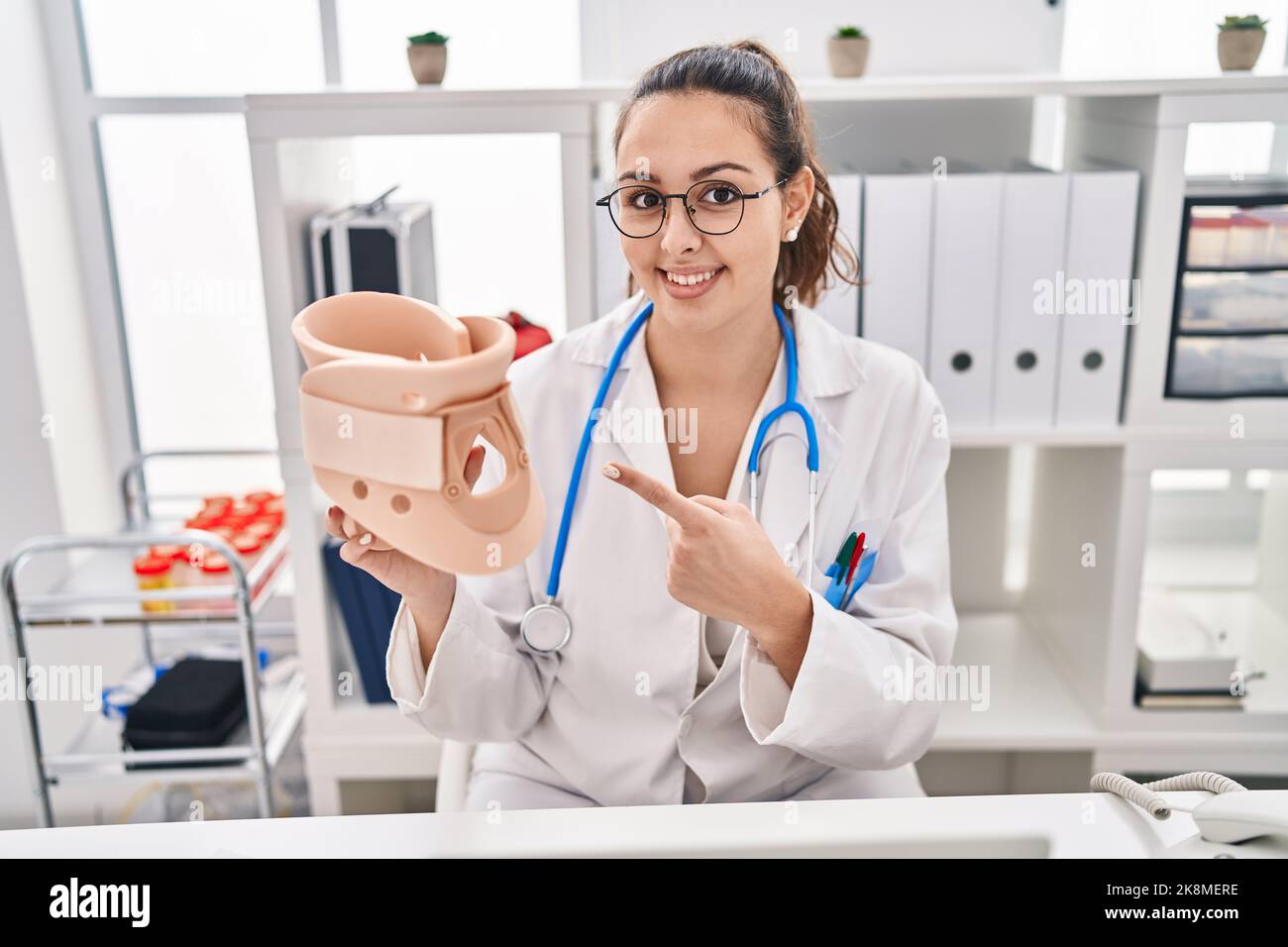 Young hispanic doctor woman holding cervical neck collar smiling happy ...