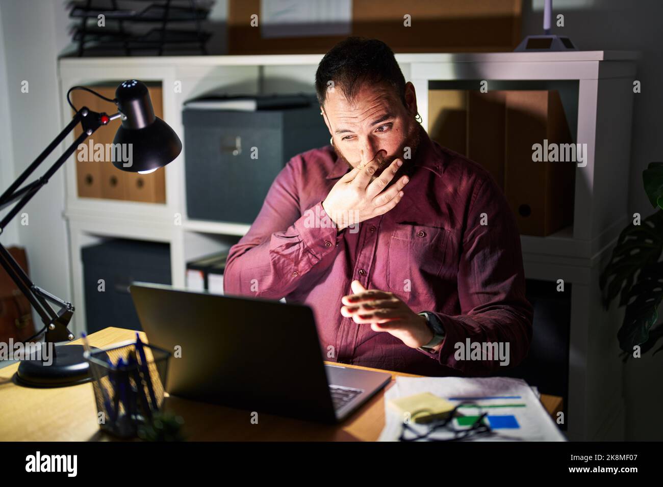 Plus size hispanic man with beard working at the office at night ...