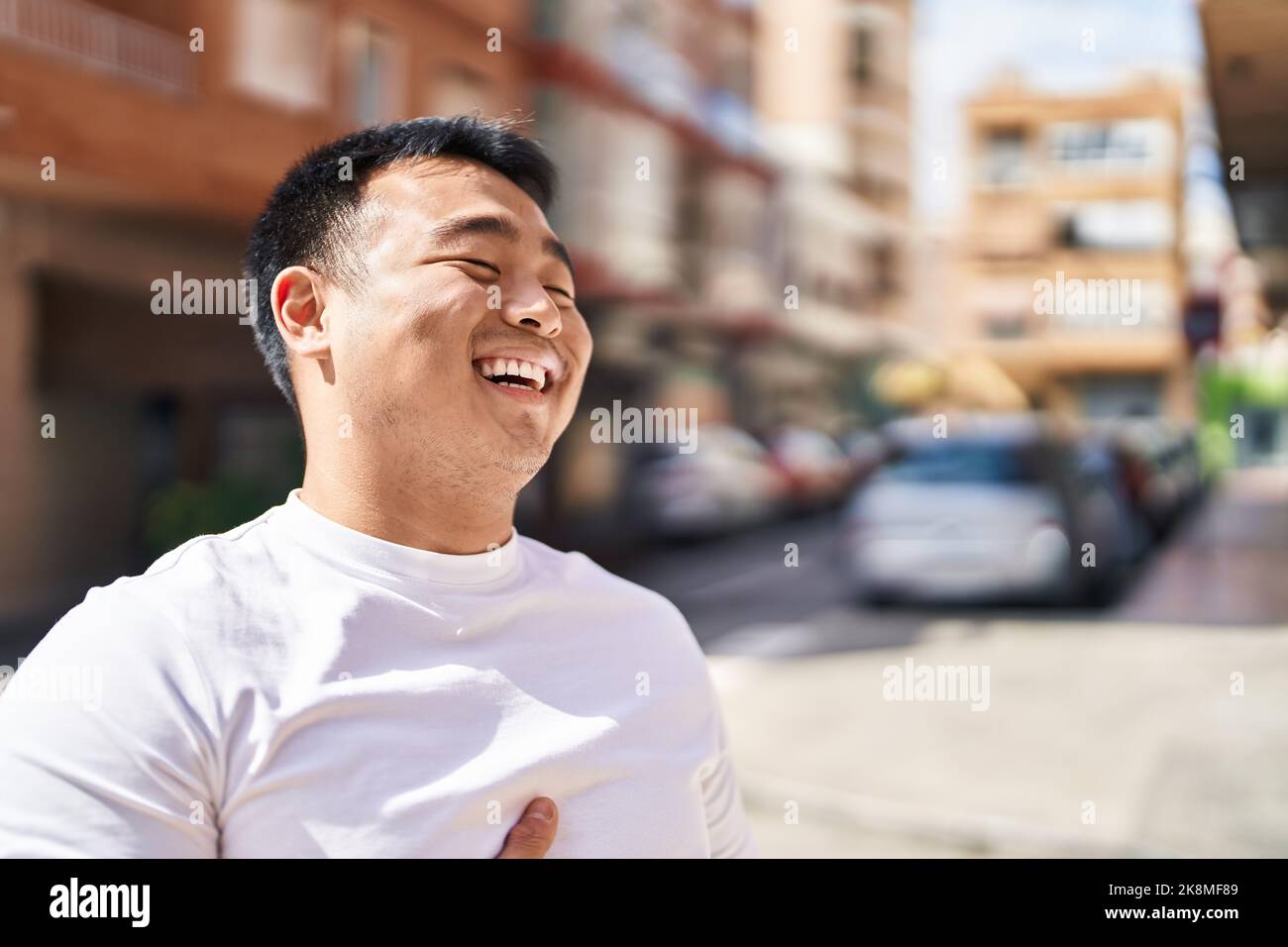 Young chinese man smiling confident standing at street Stock Photo - Alamy
