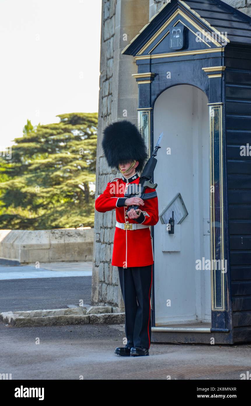 A vertical shot of a british guard on a red uniform outside an entrance ...