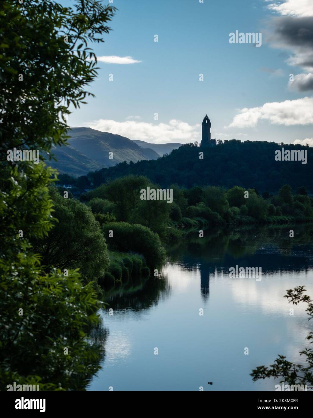A vertical shot of a small lake surrounded by trees with the Wallace ...