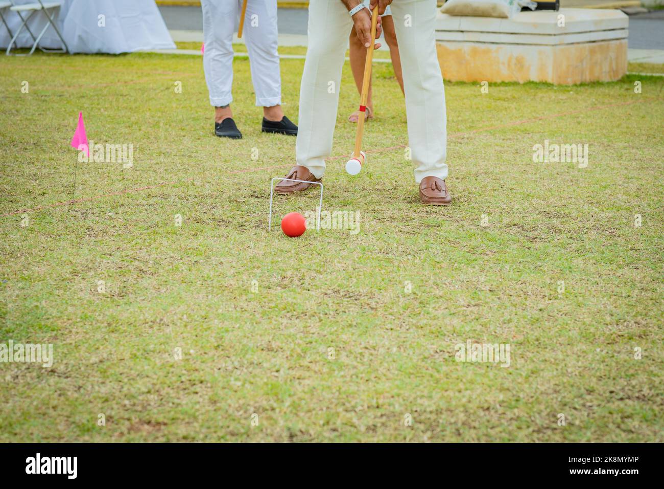 The partial view of a man playing the croquet game on the grass Stock ...